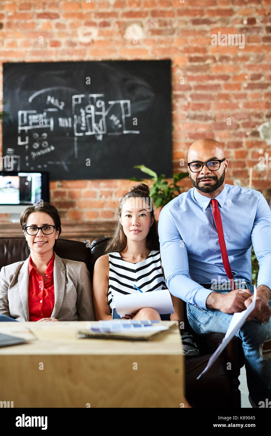 Group of three employees sitting by workplace during meeting Stock ...