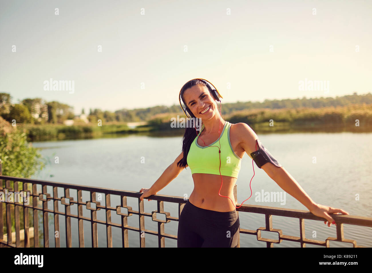 Spanish girl running in headphones smiling in park Stock Photo - Alamy