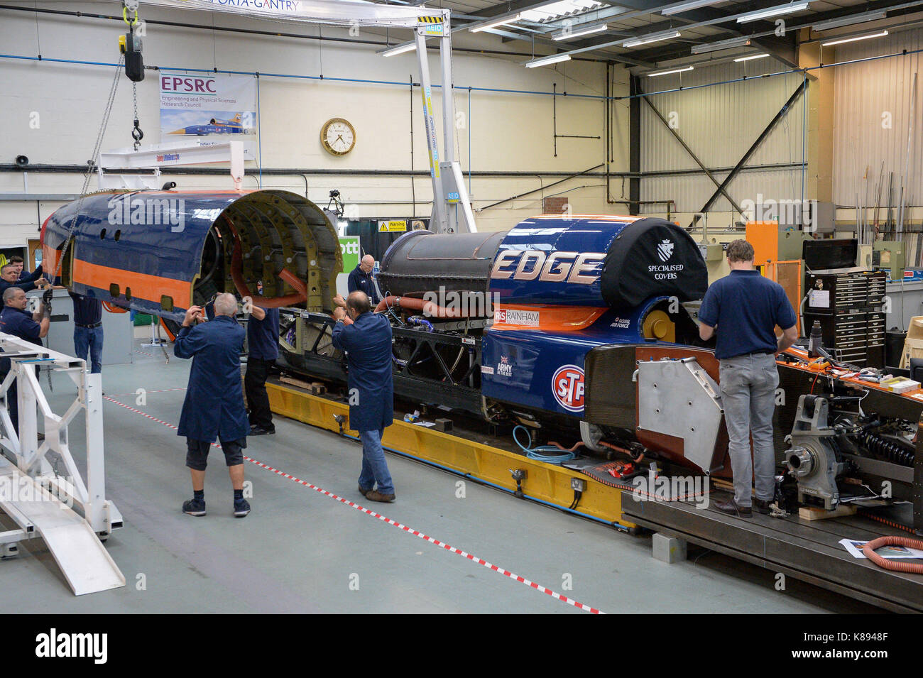 Engineers move the upper chassis, which houses the jet engine, on a ...