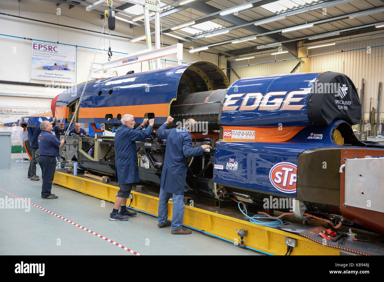 Engineers move the upper chassis, which houses the jet engine, on a ...