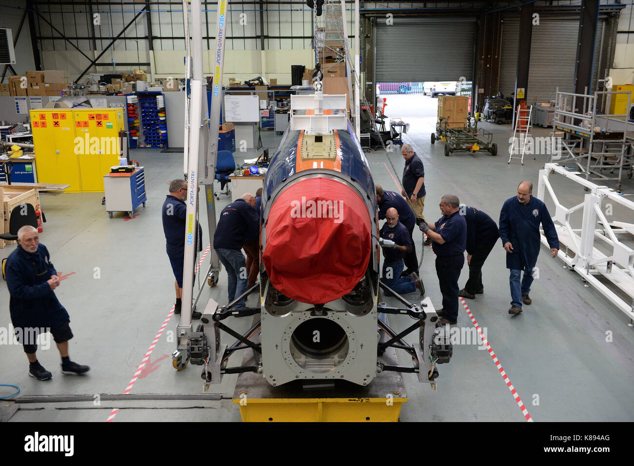 Engineers move the upper chassis, which houses the jet engine, on a ...