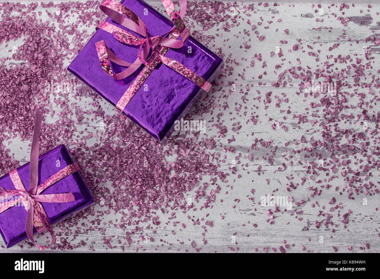 Holiday concept with pink and purple gift boxes and purple sparkles on ...