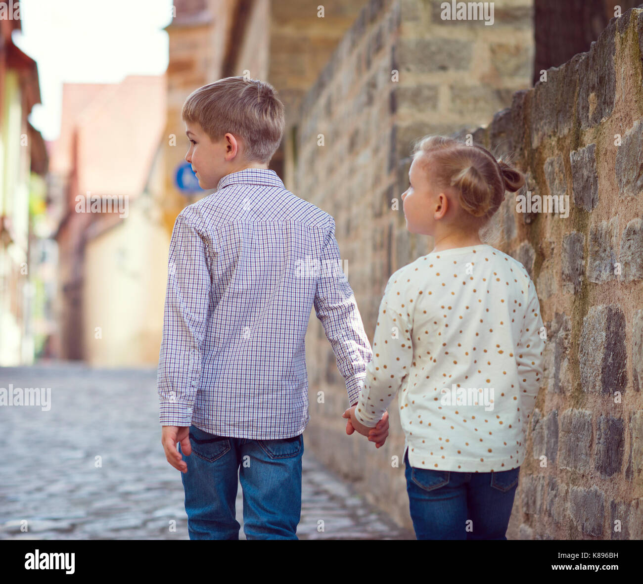 Two kids walking hand in hand hi-res stock photography and images - Alamy
