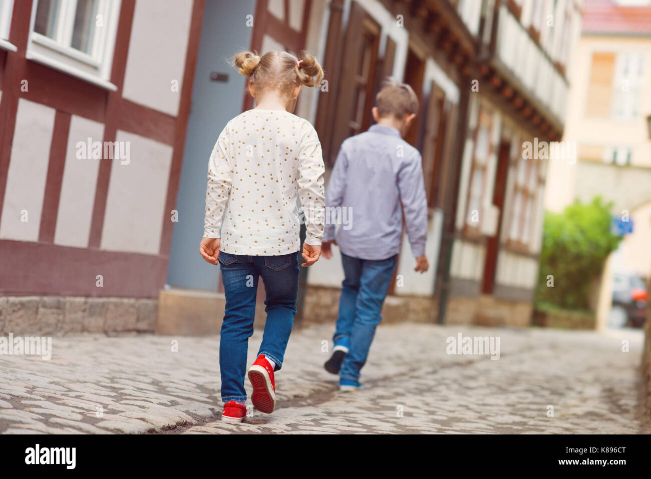 Two kids walking hand in hand hi-res stock photography and images - Alamy