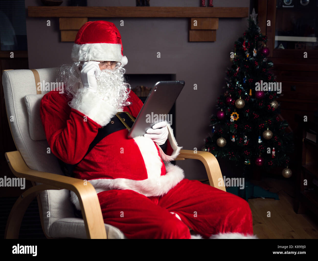 Santa claus Using Mobile Tablet Computer in home Stock Photo - Alamy