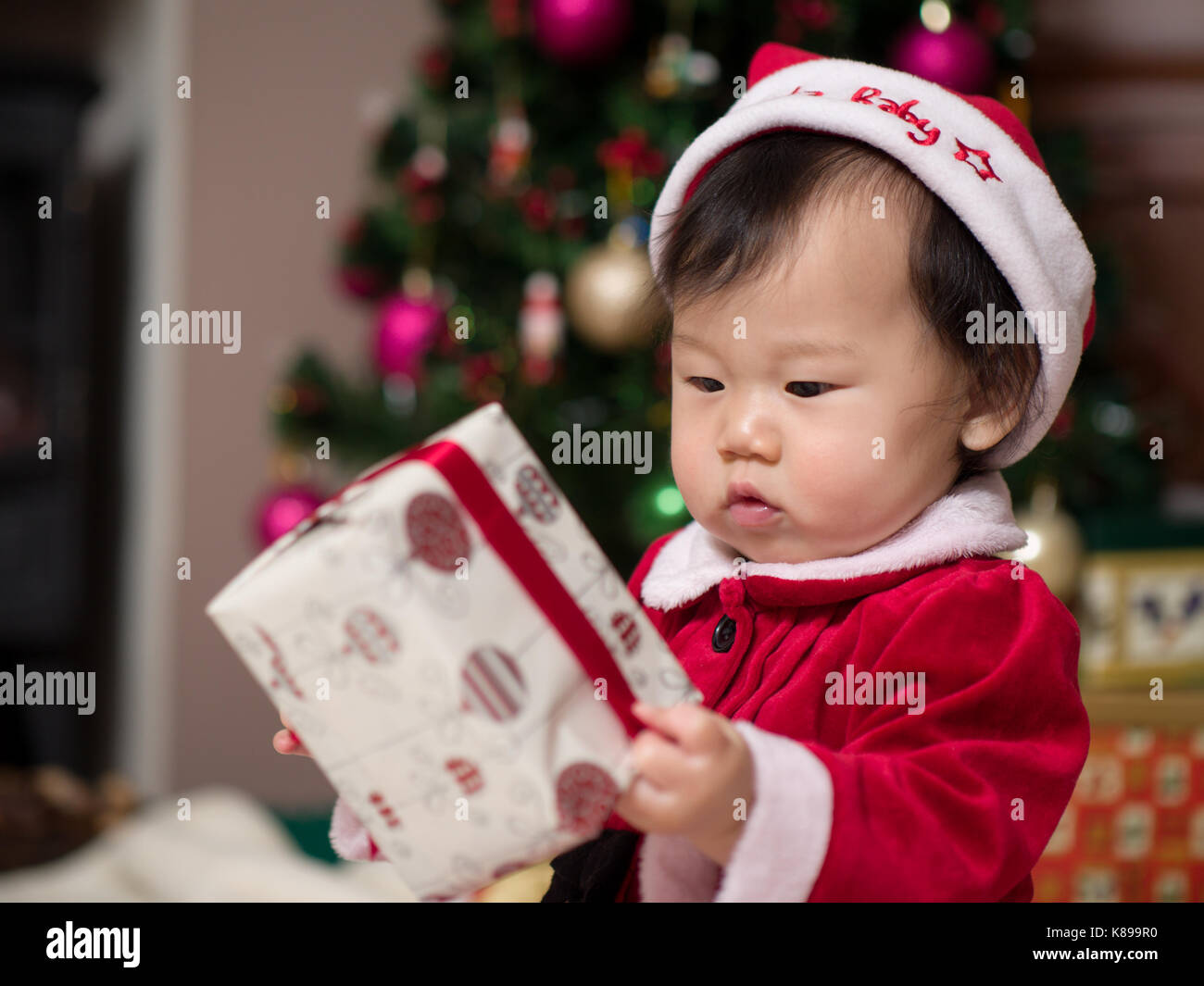 Asian baby girl in a Santa costume with a gift box Stock Photo - Alamy
