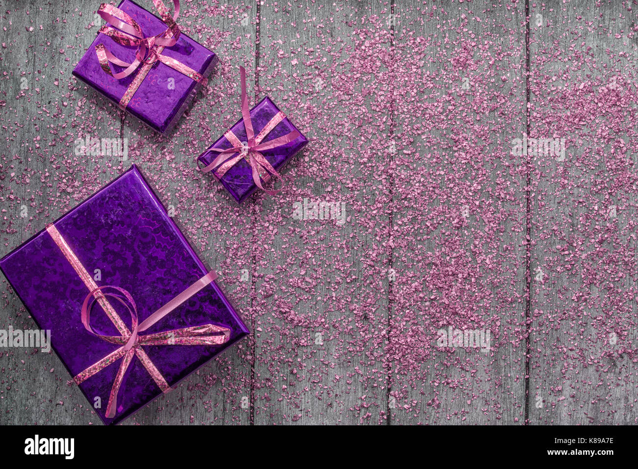Holiday concept with pink and purple gift boxes and purple sparkles on ...