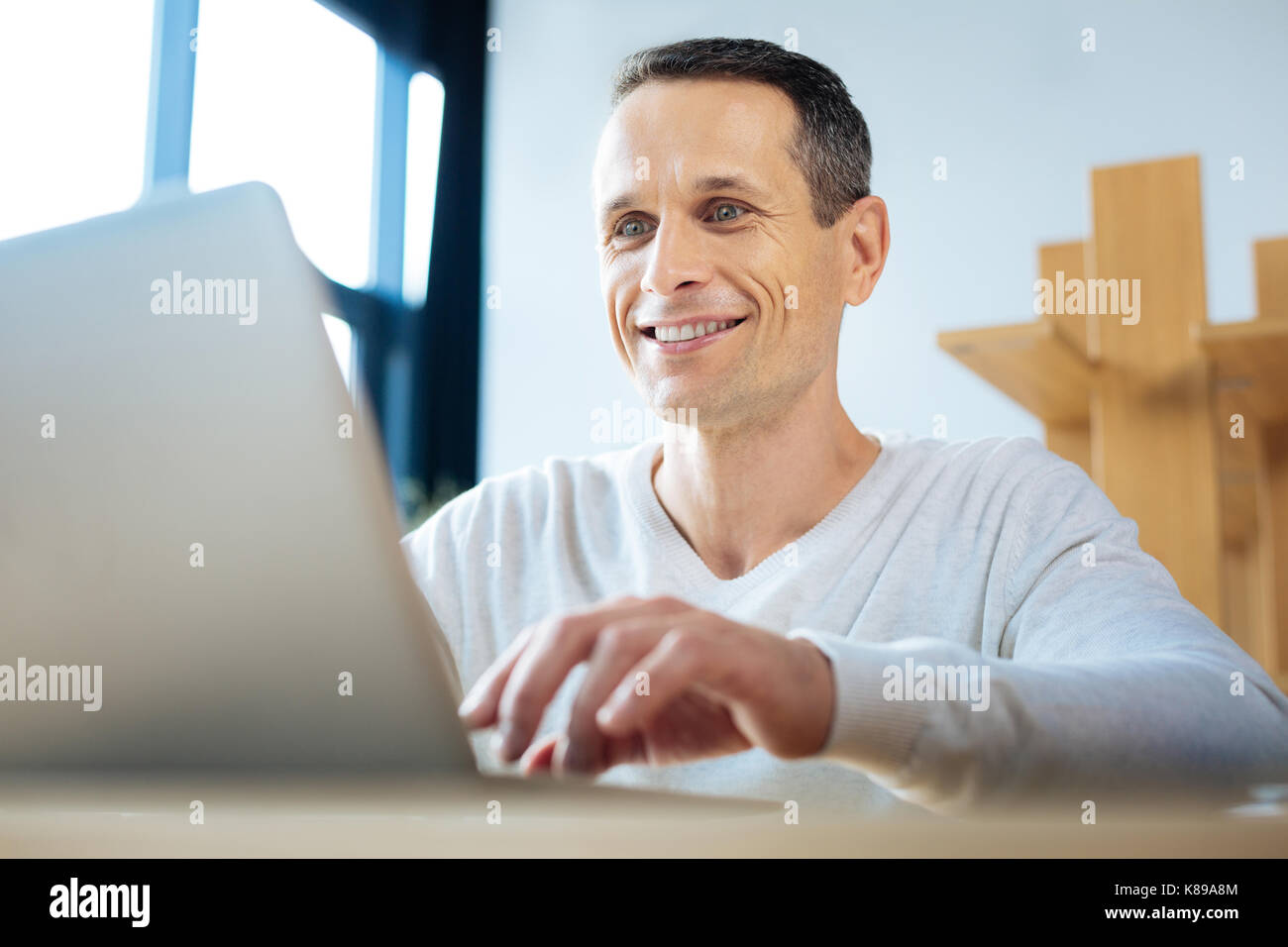Cheerful positive businessman looking at the laptop screen Stock Photo ...