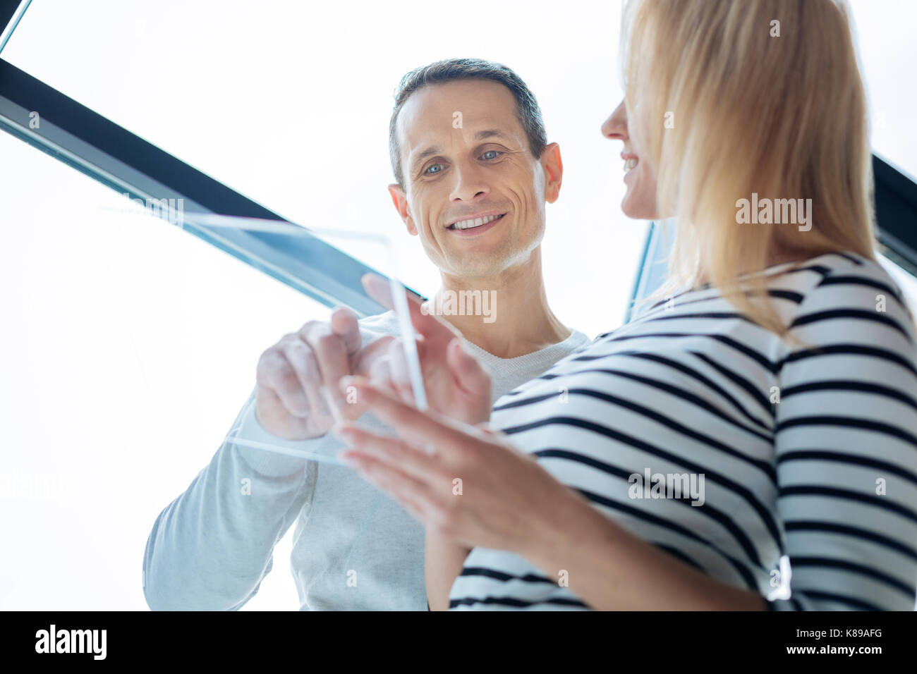 Delighted friendly man pointing at the tablet screen Stock Photo - Alamy