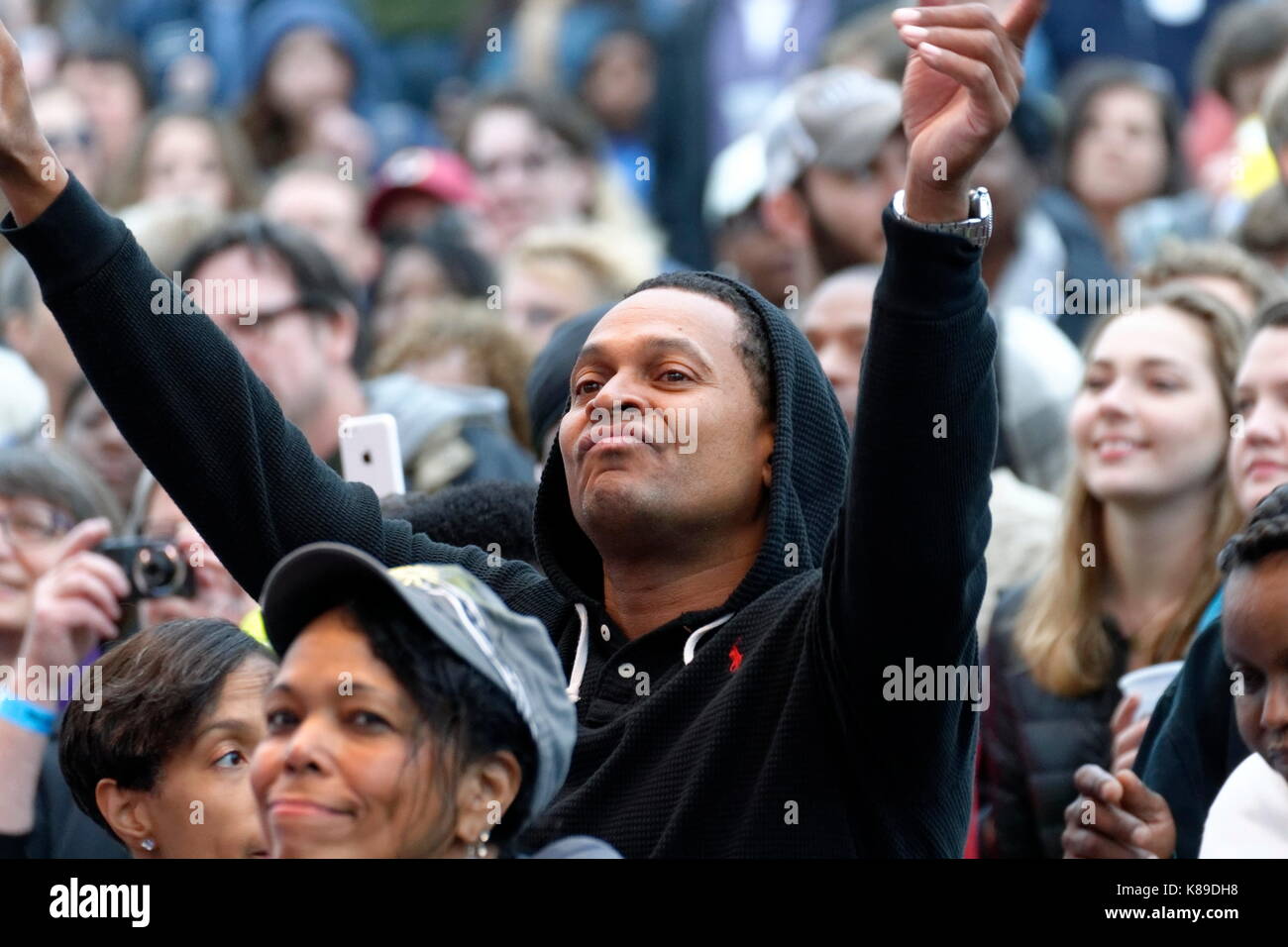 Man in festival crowd, outdoors, standing with arms raised Stock Photo ...