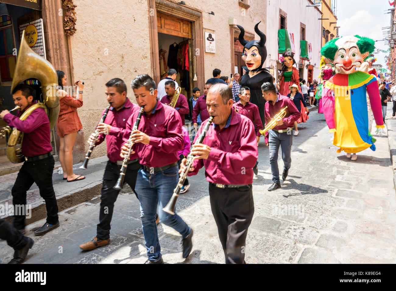 A brass band leads a procession of giant papier mache puppets called ...