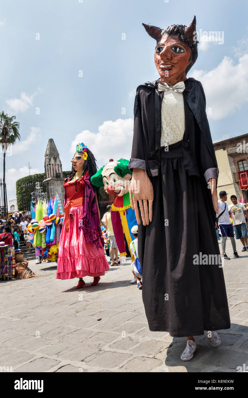Giant papier mache puppets called mojigangas dance in front of the ...