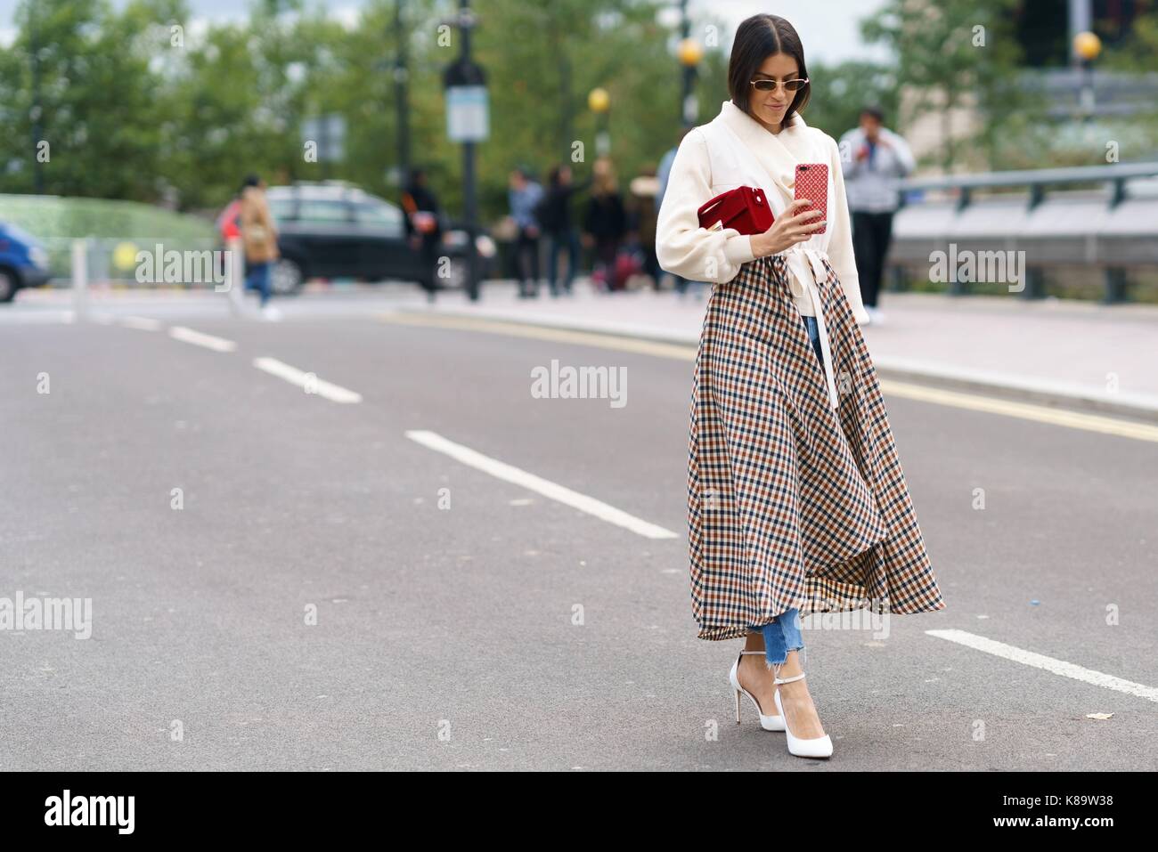 A chic showgoer posing outside the Versus Versace runway show during ...
