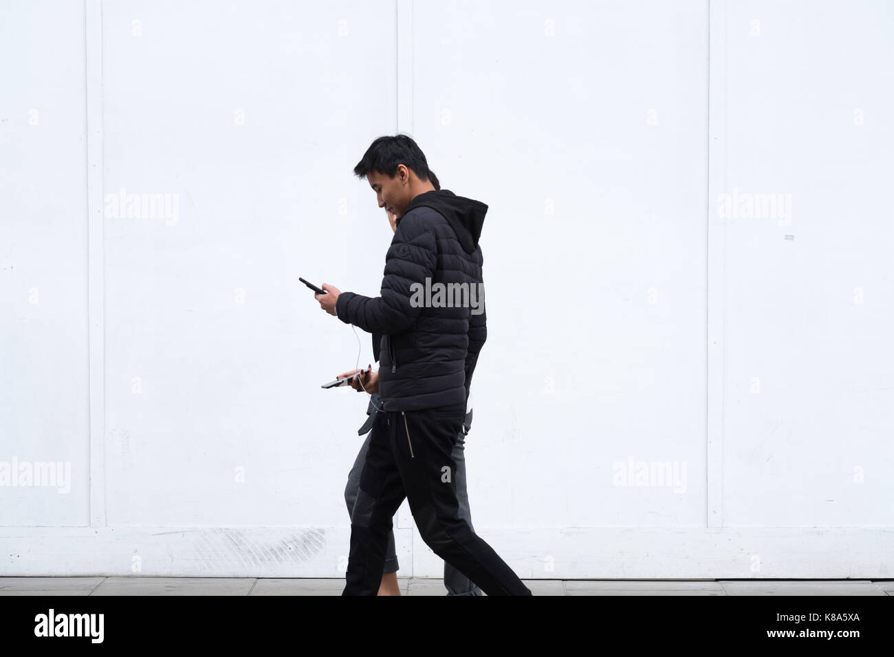 Walking with cell phones hi-res stock photography and images - Alamy