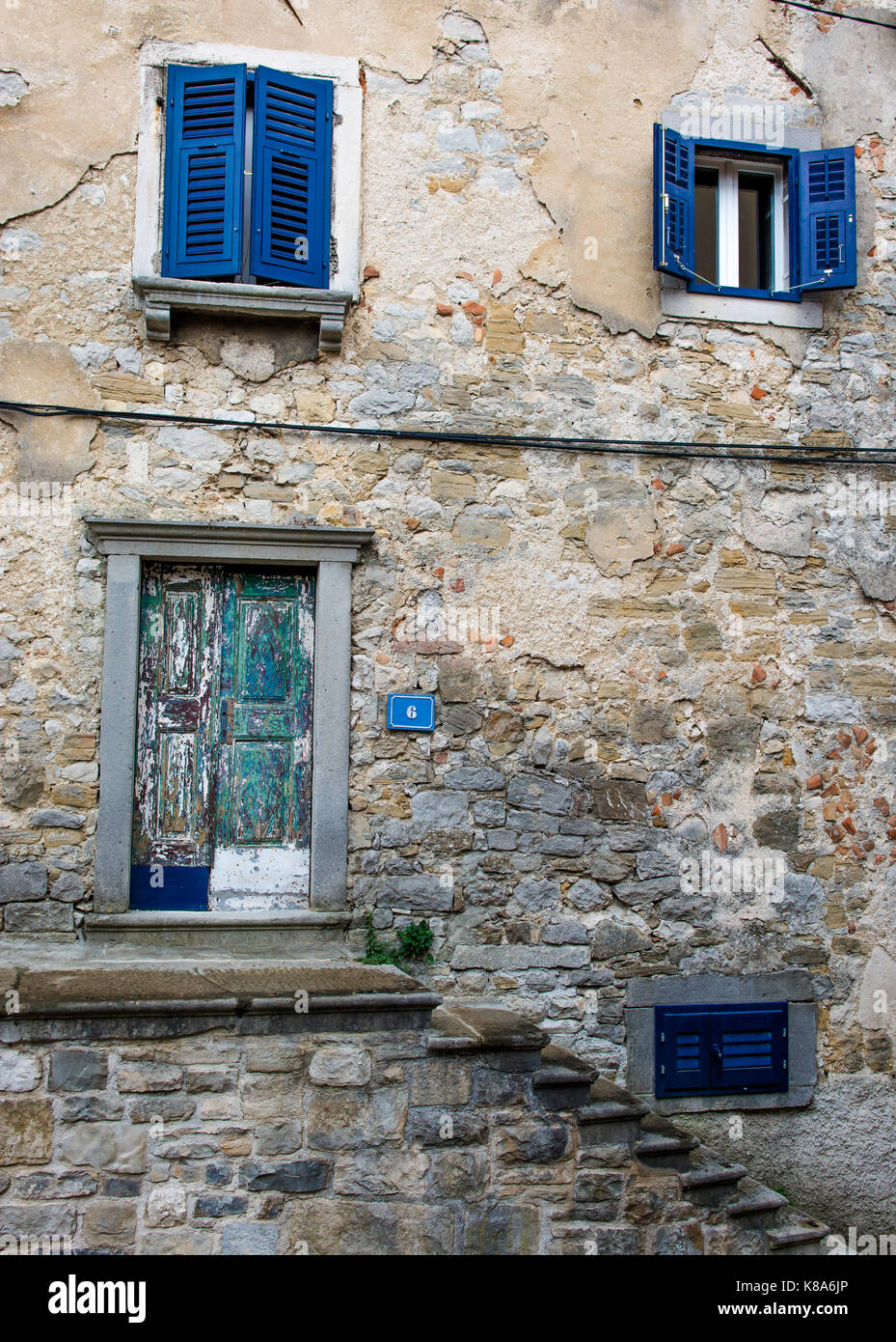 House with Blue Windows and Weathered Door Stock Photo - Alamy