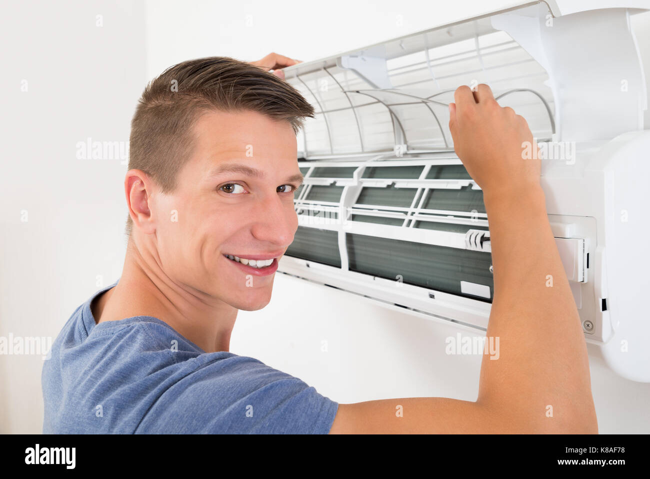 Young Happy Man Cleaning Air Conditioning System At Home Stock Photo ...