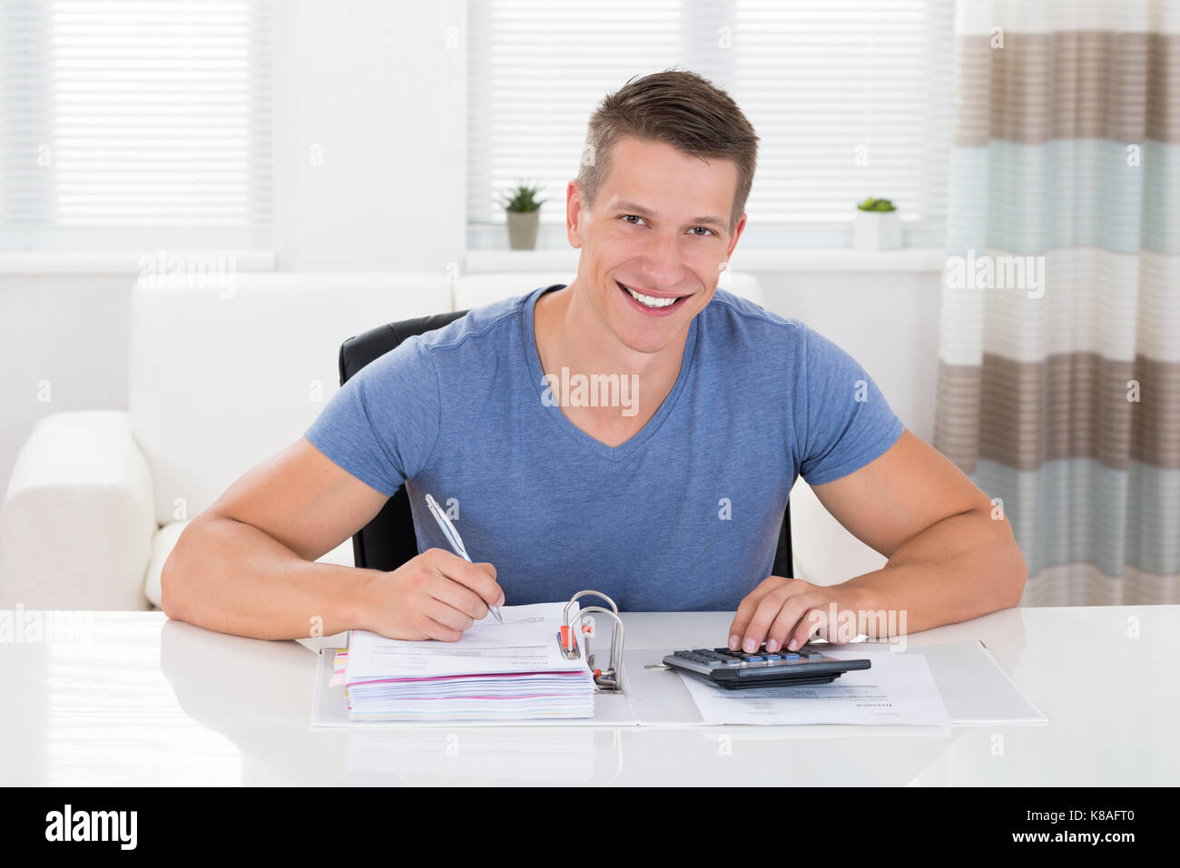 Portrait Of Happy Man Doing Calculation At Home Stock Photo - Alamy