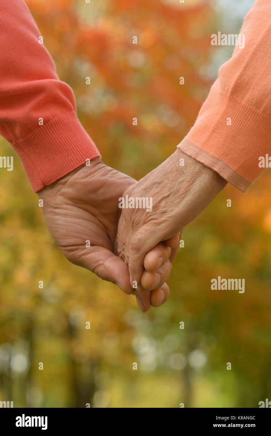 Elderly couple holding hands Stock Photo - Alamy