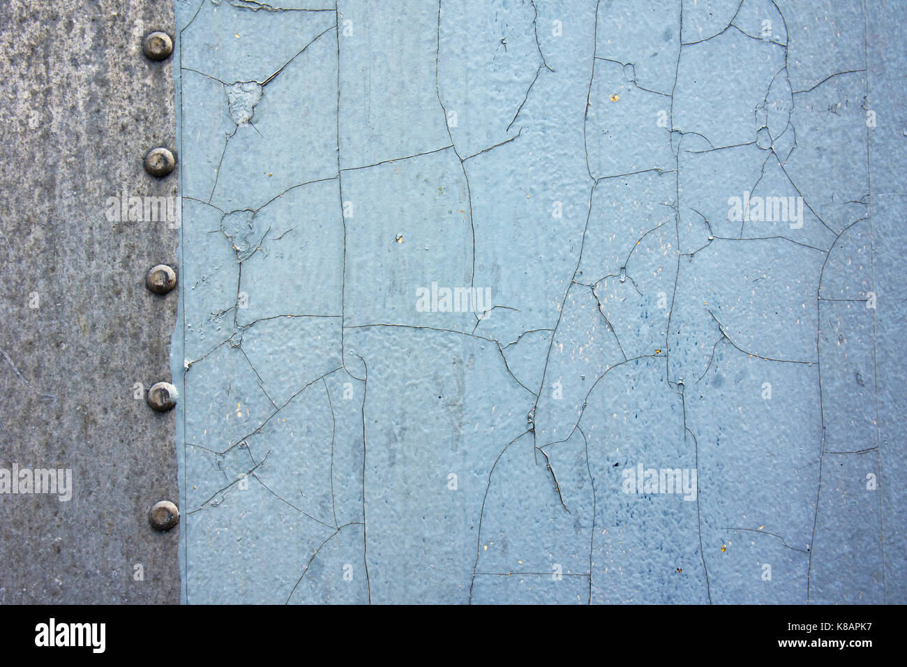 Metal with bolts next to a blue painted wall with cracks for a unique ...