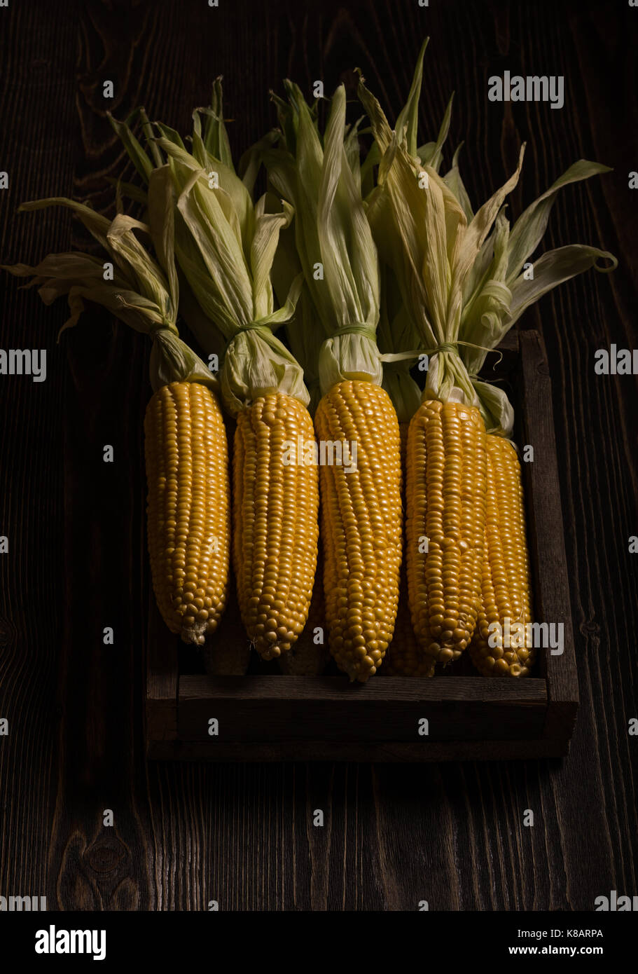Box of fresh corn cobs on the dark rough wood Stock Photo - Alamy