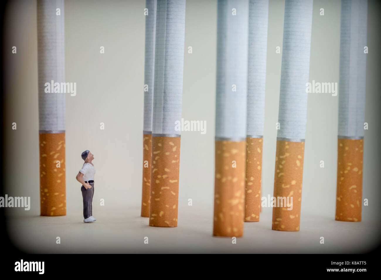 Figure of a man miniature between cigarettes, isolated on white ...