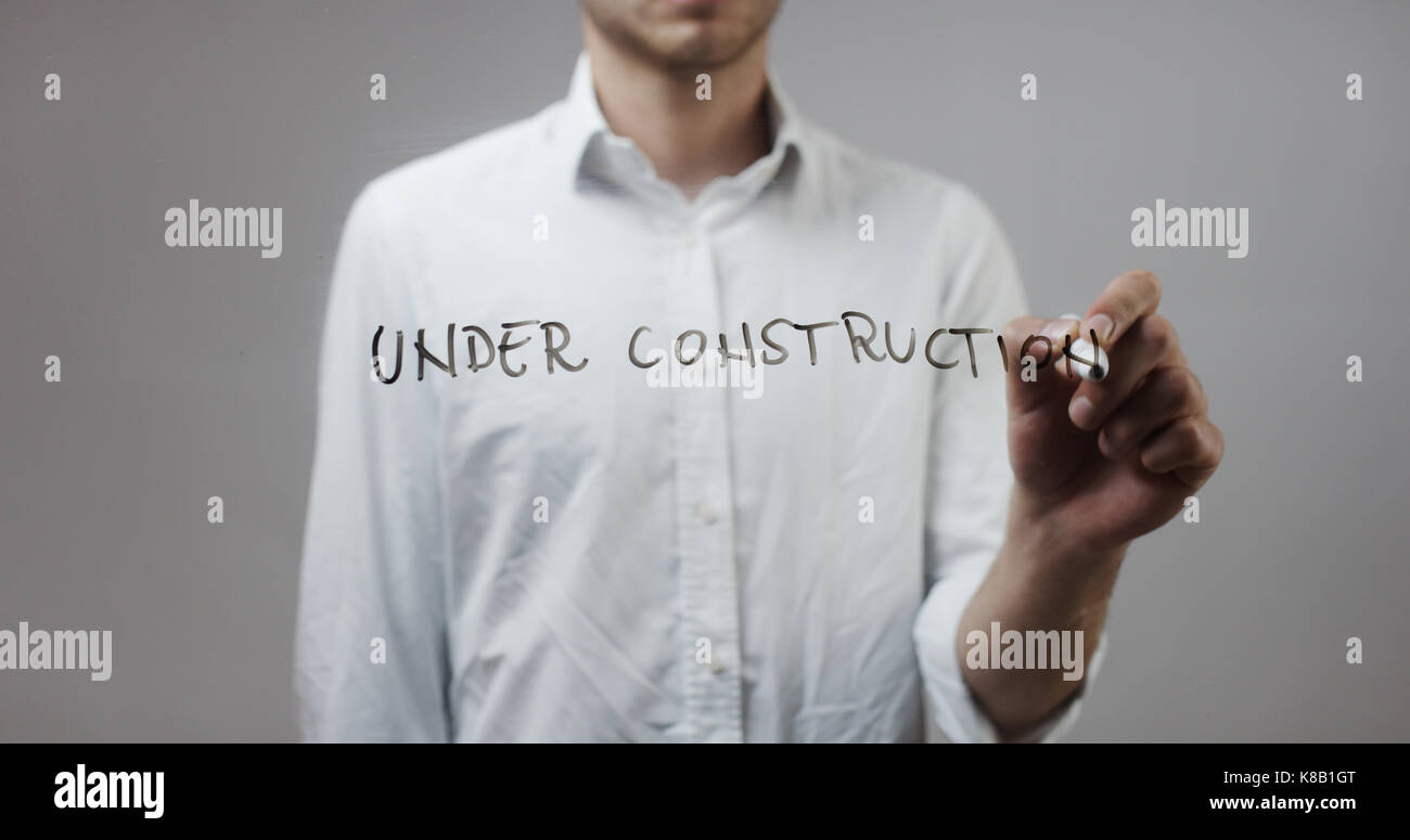 Under construction , Man Writing on Glass Stock Photo - Alamy