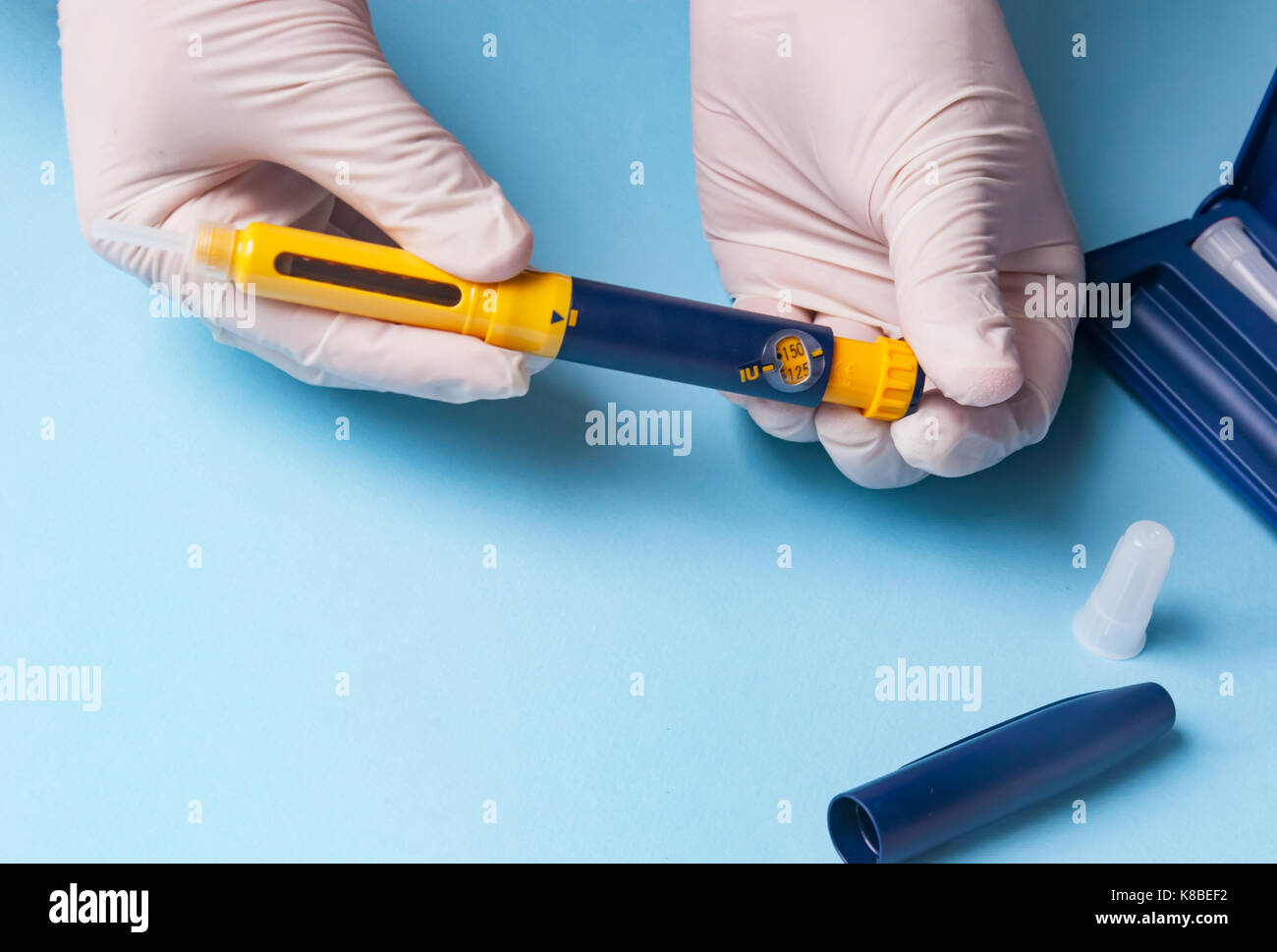 A man in medical gloves holds a syringe for subcutaneous injection of ...