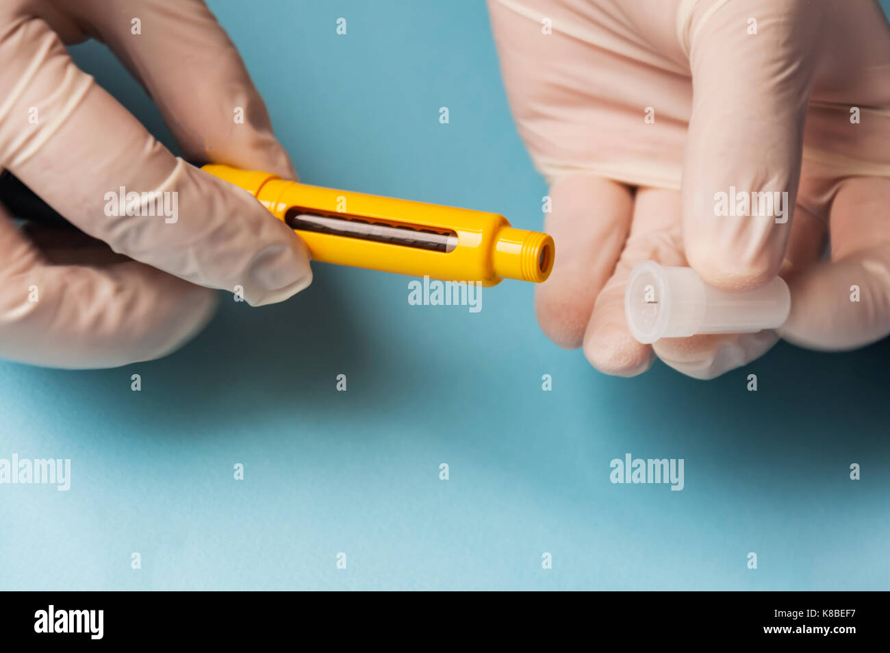 A man in medical gloves holds a syringe for subcutaneous injection of ...