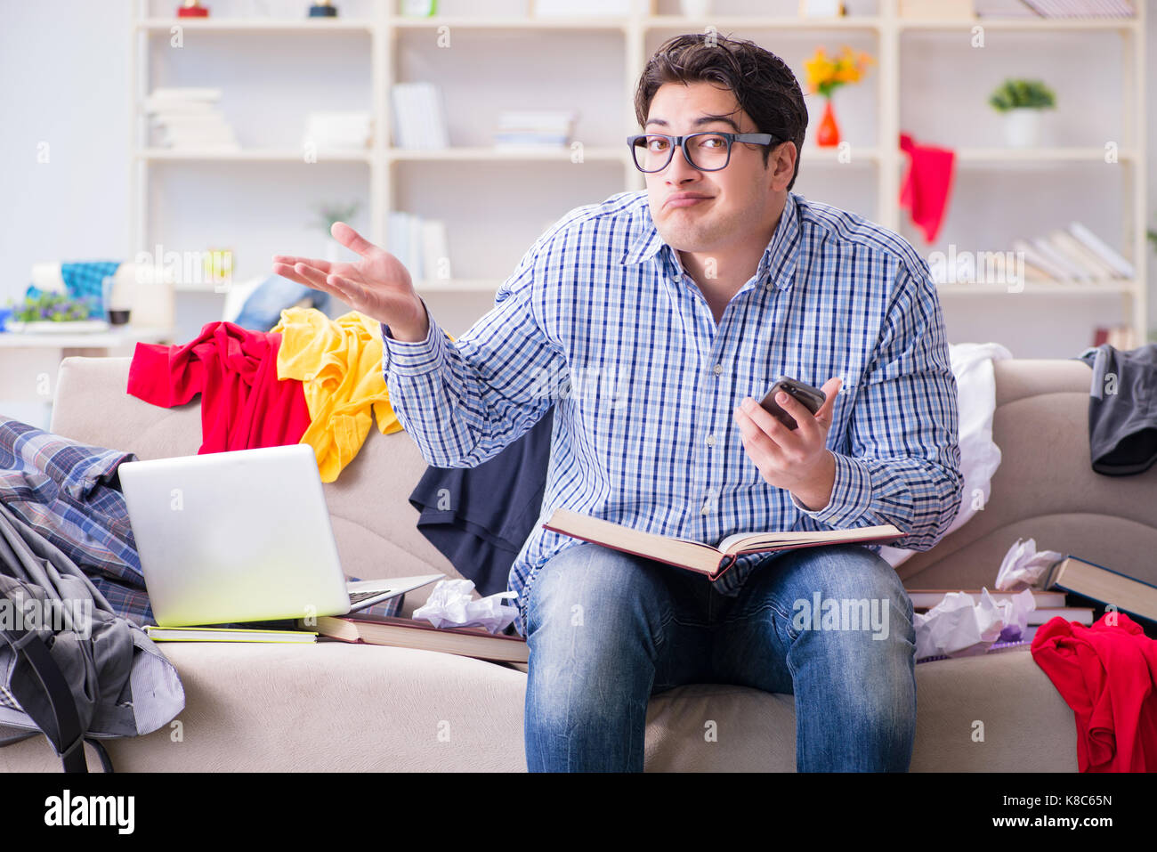 Young man working studying in messy room Stock Photo - Alamy