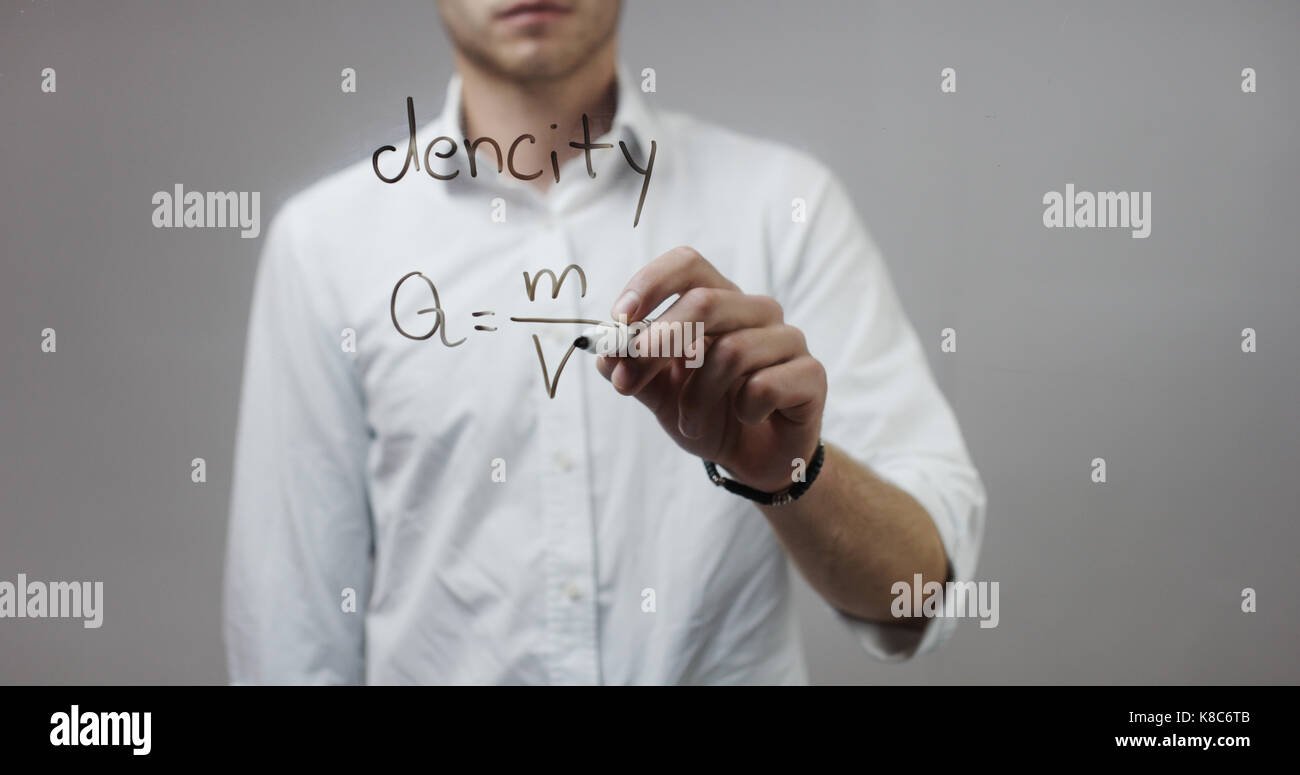 Density formula , Man Writing on Glass Stock Photo - Alamy