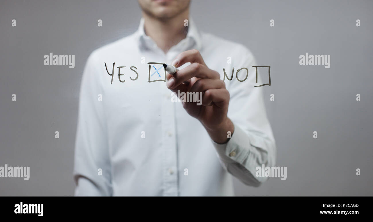 Yes or no, Yes checked , Man Writing on Glass Stock Photo - Alamy