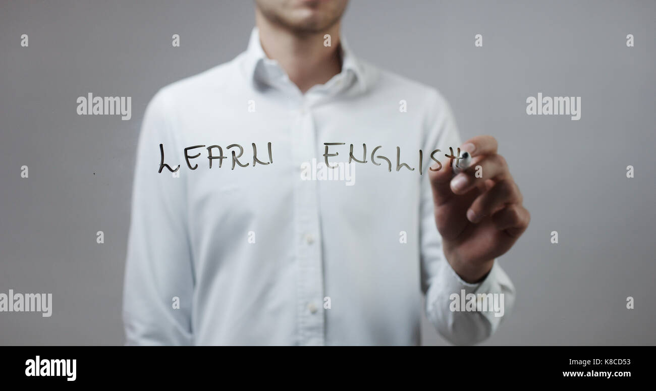 Learn english , Man Writing on Glass Stock Photo - Alamy