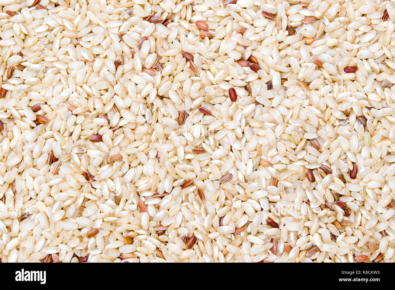 Yellow rice grains on pile background pattern Stock Photo - Alamy