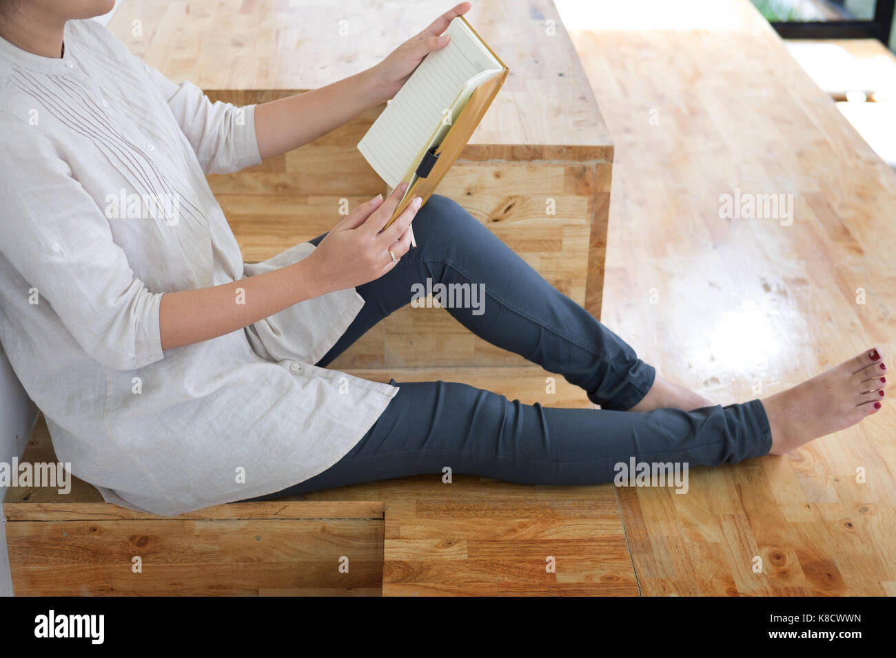 Thoughtful female student sitting Serious reading a book in a library ...