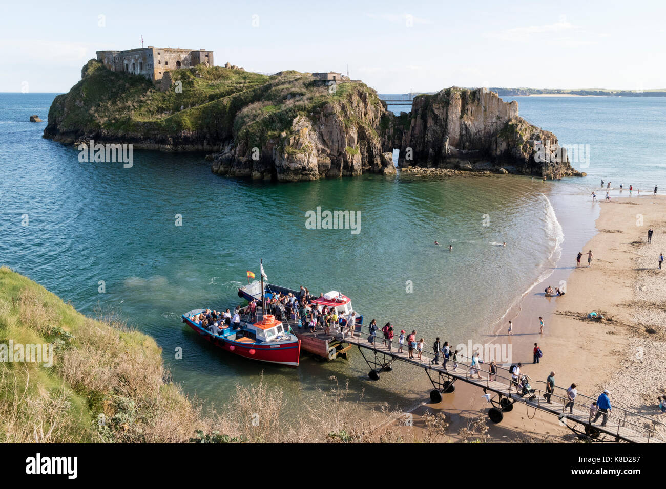 Tourists alight from boat at jetty on beach at Tenby following trip to ...