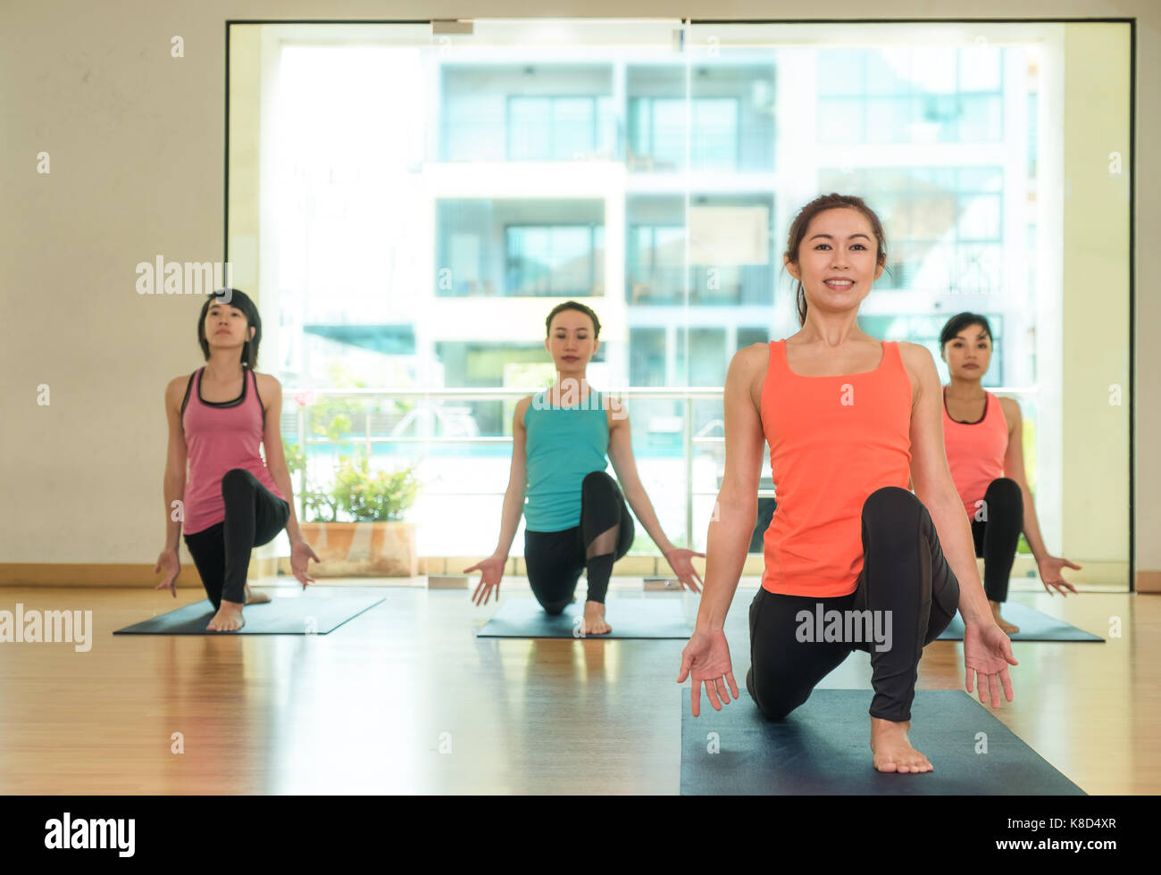 Yoga class in studio room,Group of people doing balance low lunge poses ...