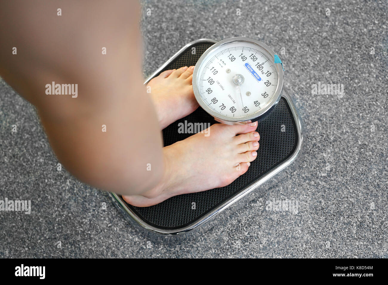 The correct weight of the body. Woman weighs on bathroom scales Stock ...