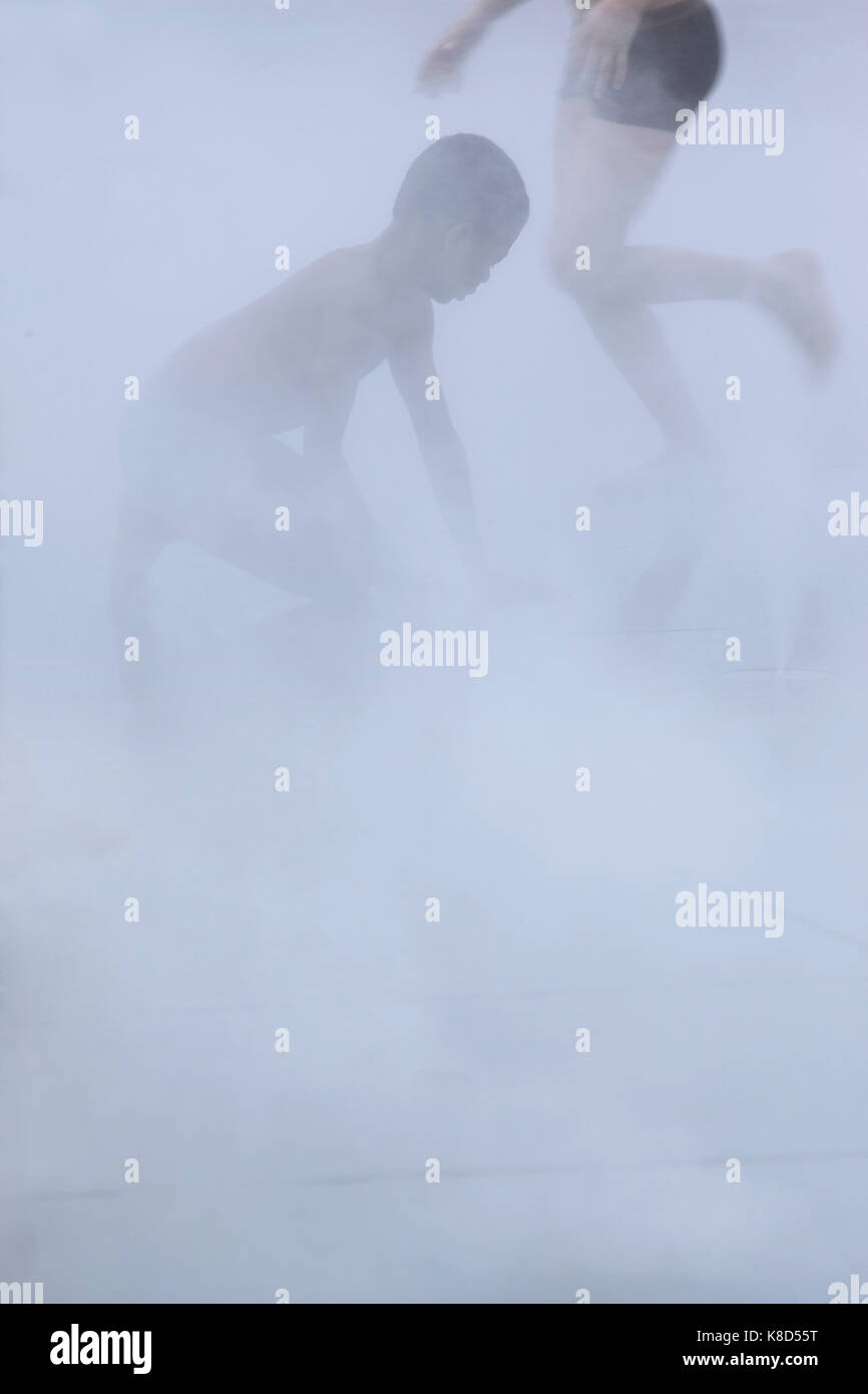 Two kids playing in the mist Stock Photo - Alamy