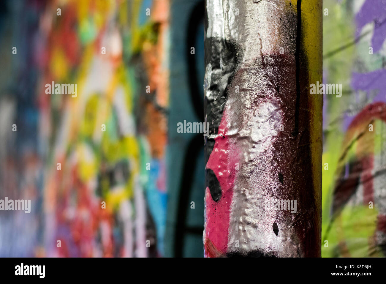 Graffiti on a down pipe with a graffiti covered wall in the background ...