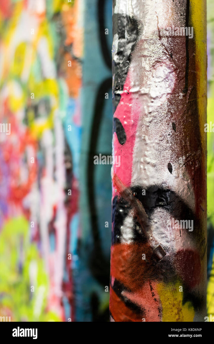 Graffiti on a down pipe with a graffiti covered wall in the background ...