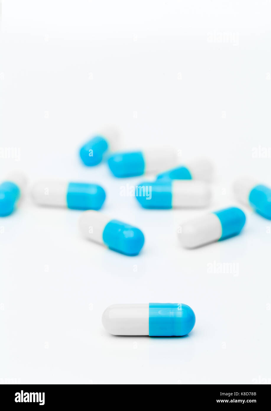 Blue drug pills on white table Stock Photo - Alamy
