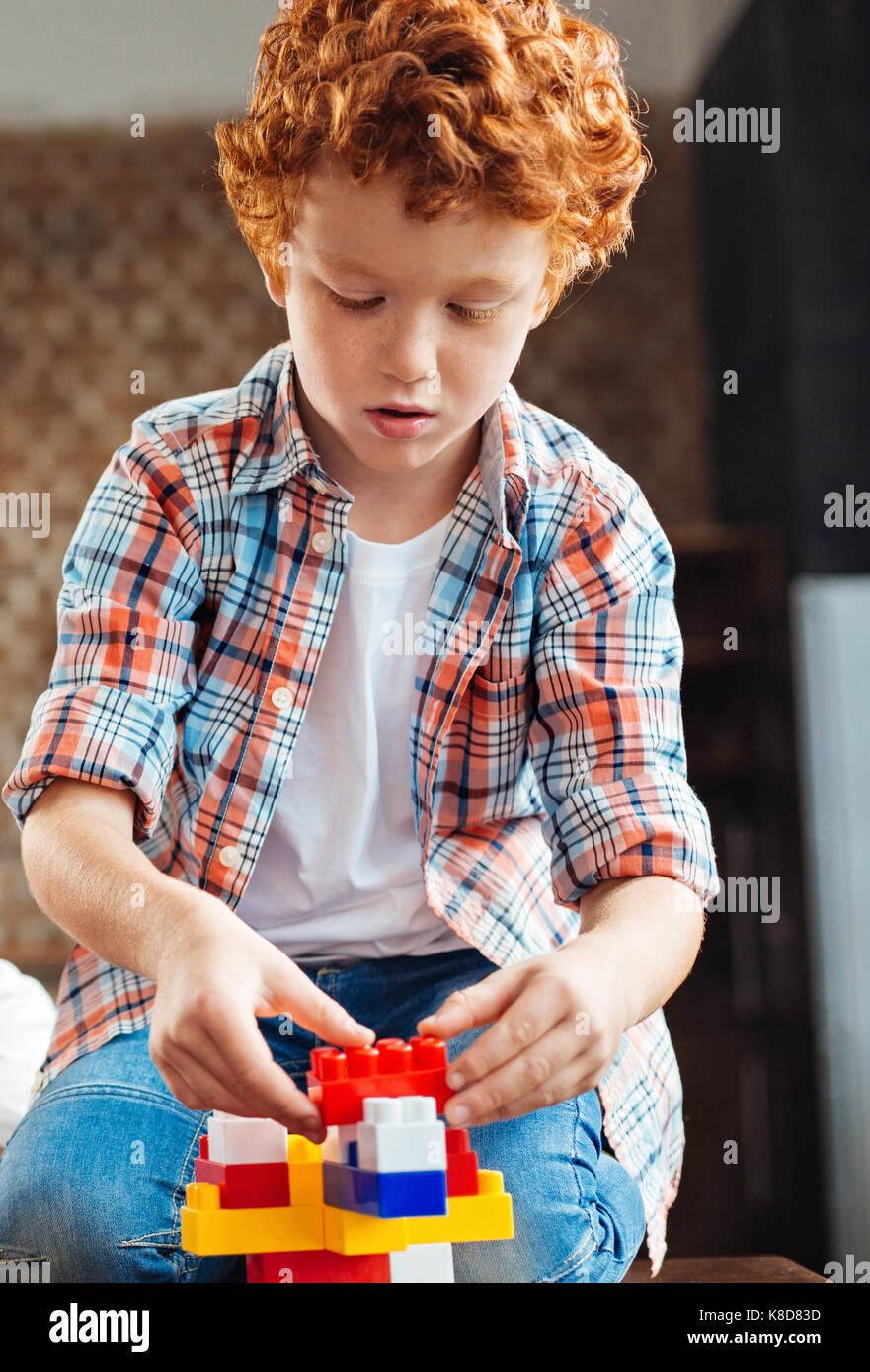 Concentrated little boy playing with building blocks Stock Photo - Alamy
