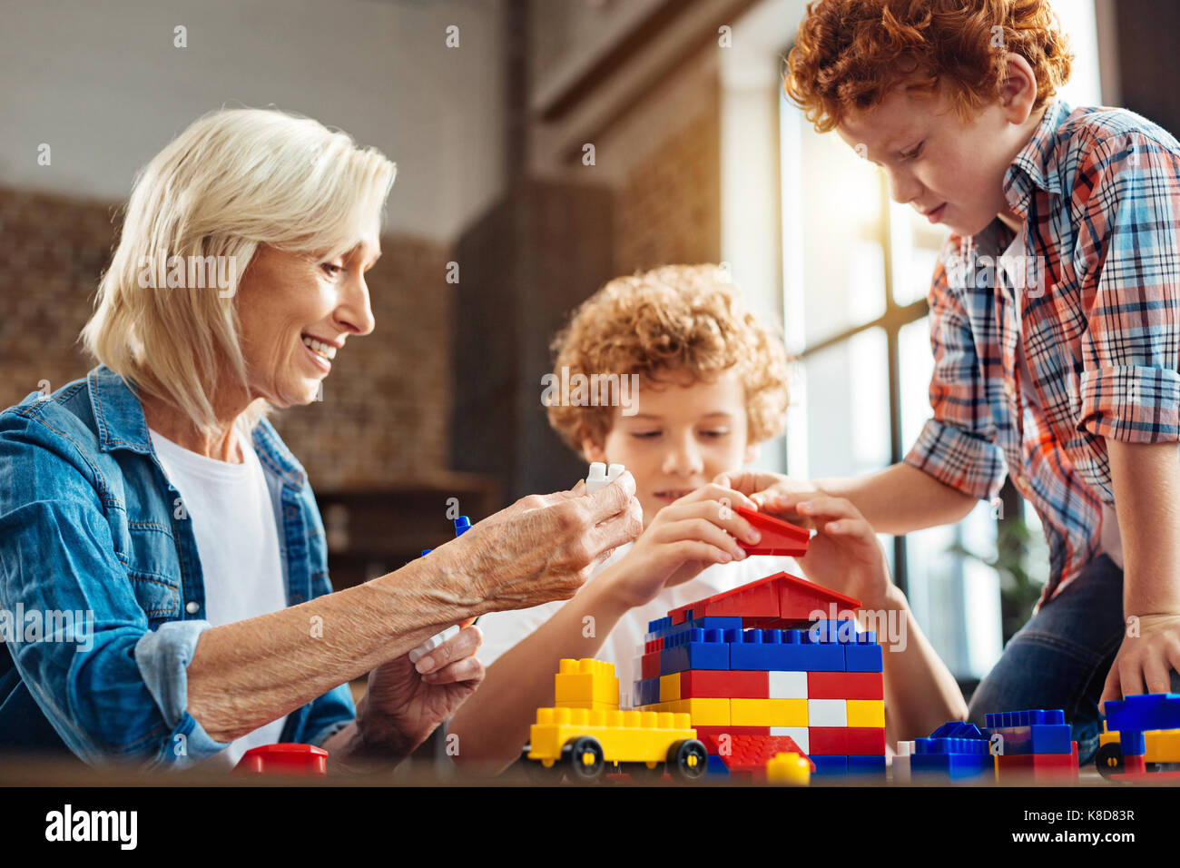 Positive minded family members playing with construction set Stock ...