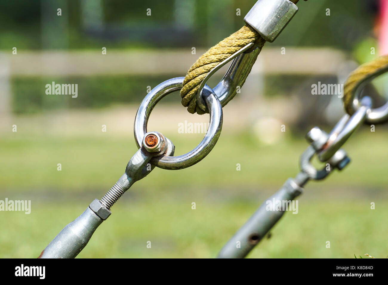 End of swinging rope hang on metal construction in a park. Rough rope ...