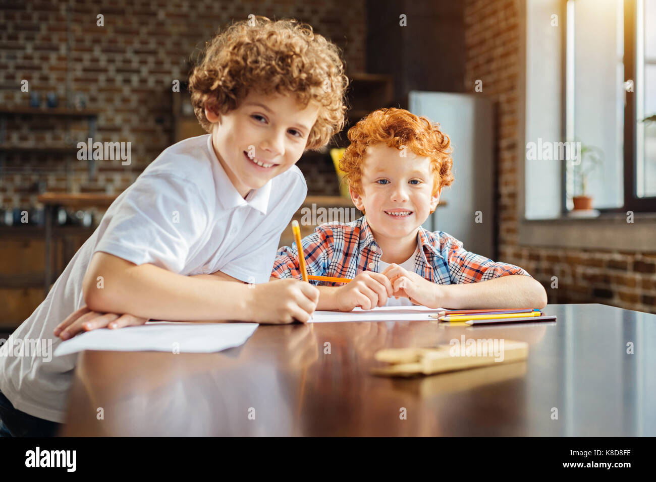 Cheerful boys grinning broadly for camera while drawing Stock Photo - Alamy