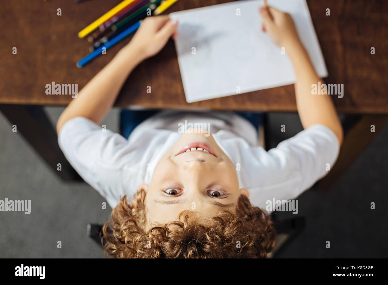 Cheerful kid drawing and smiling into camera Stock Photo - Alamy
