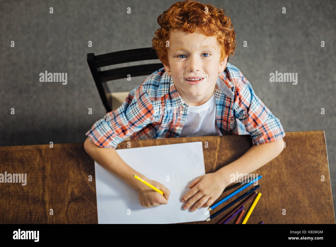 Beautiful redhead kid looking into camera while drawing Stock Photo - Alamy