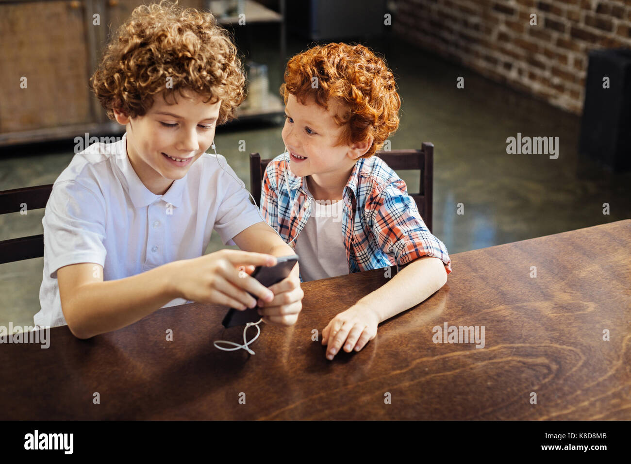 Redhead little boy listening to music with older brother Stock Photo ...
