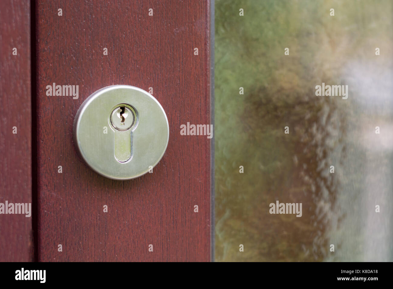 A metal keyhole on brown wooden door close up Stock Photo - Alamy