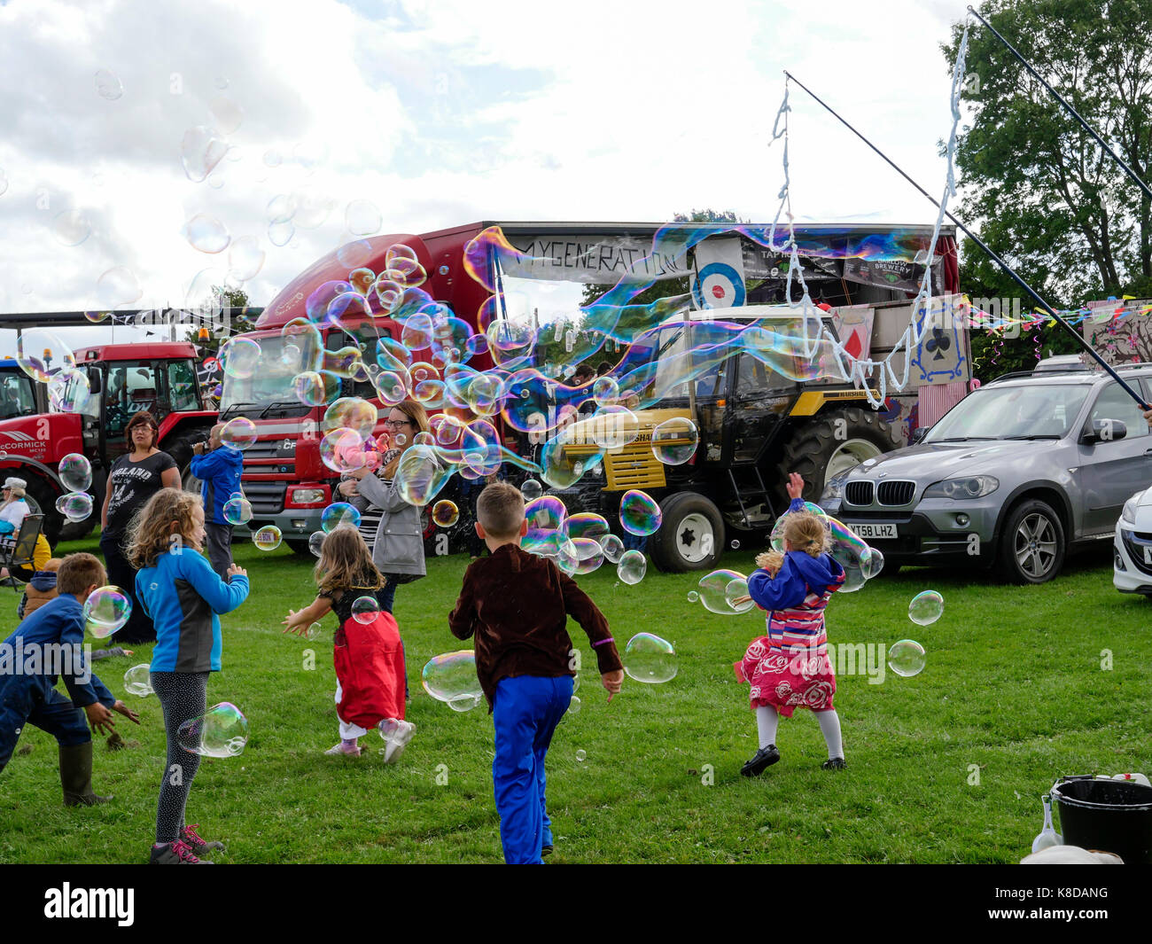 Young children chasing large bubbles Derbyshire England Stock Photo - Alamy